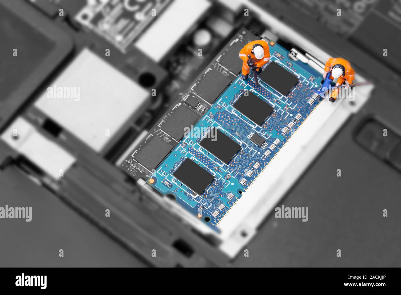 Miniature scale model construction workers installing RAM into the ...