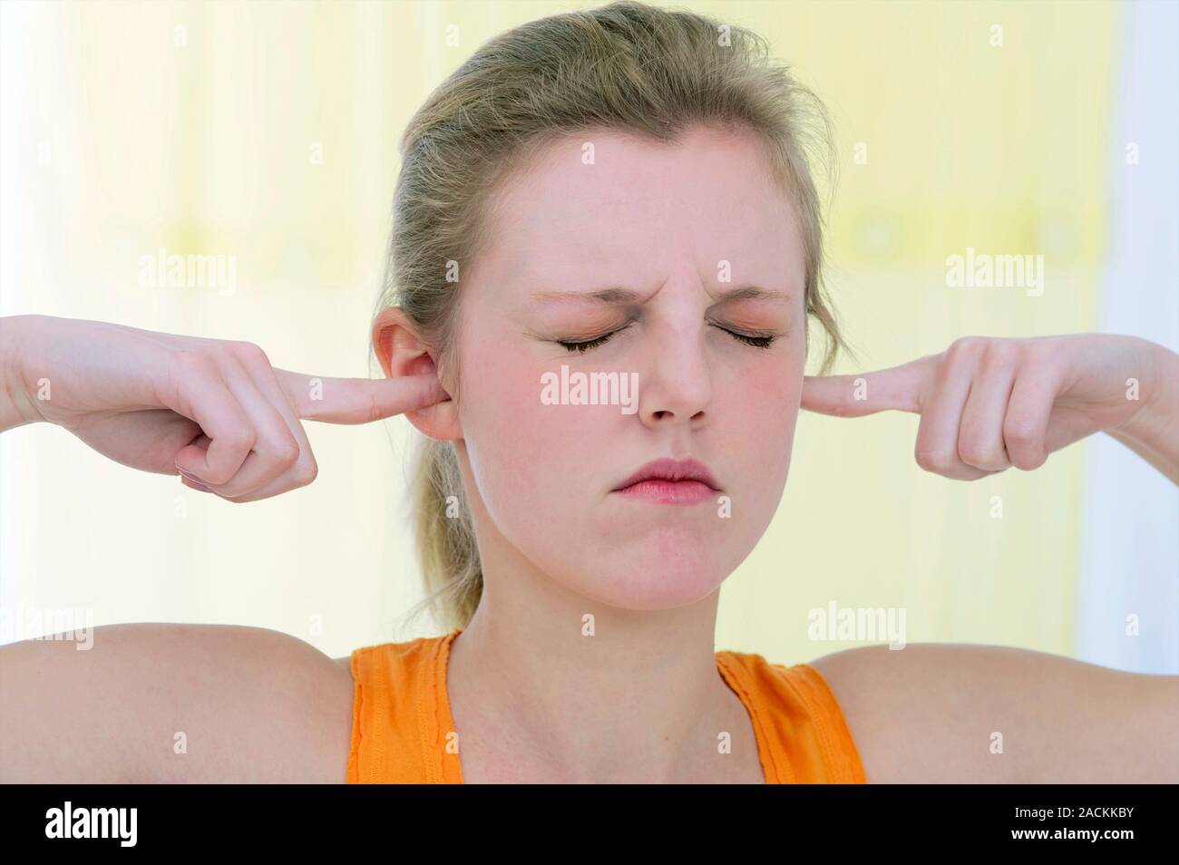 Ear disorder. Woman with her fingers in her ears. This can be a ...