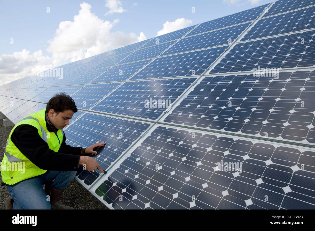 Solar panels maintenance. Worker connecting wires on a photovoltaic ...