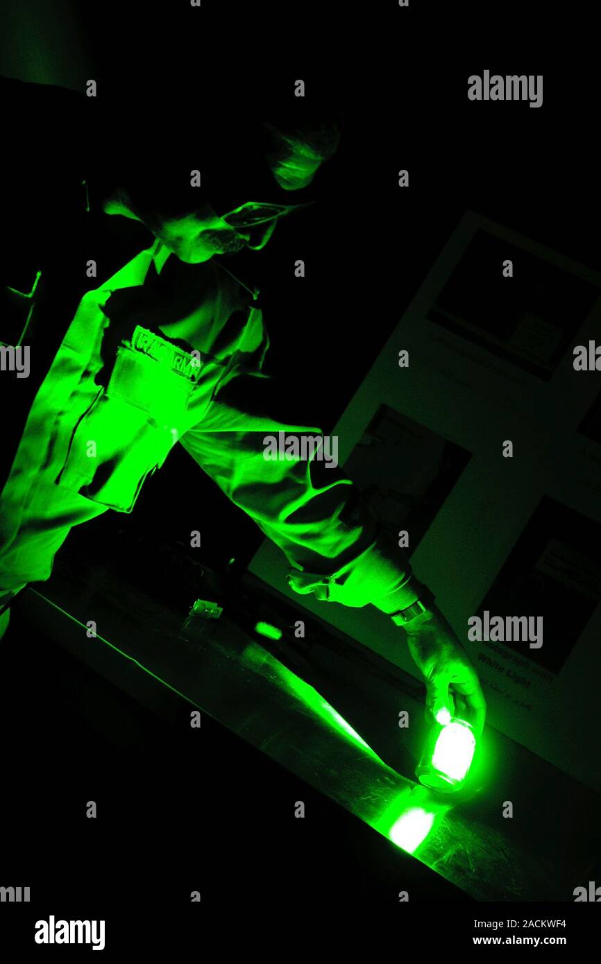 Military forensics. Iraqi army officer using a laser to check a soda ...