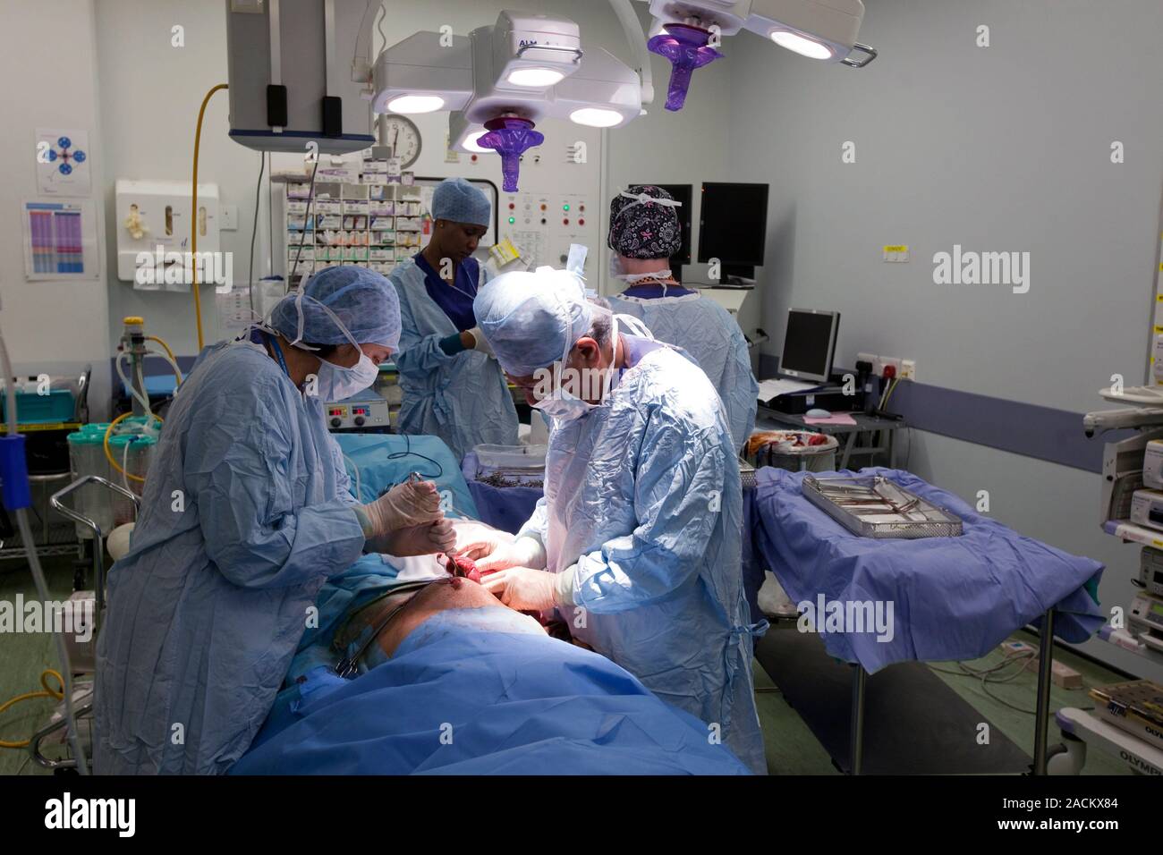 Surgeons performing surgery to remove (excise) a lesion in the shoulder ...