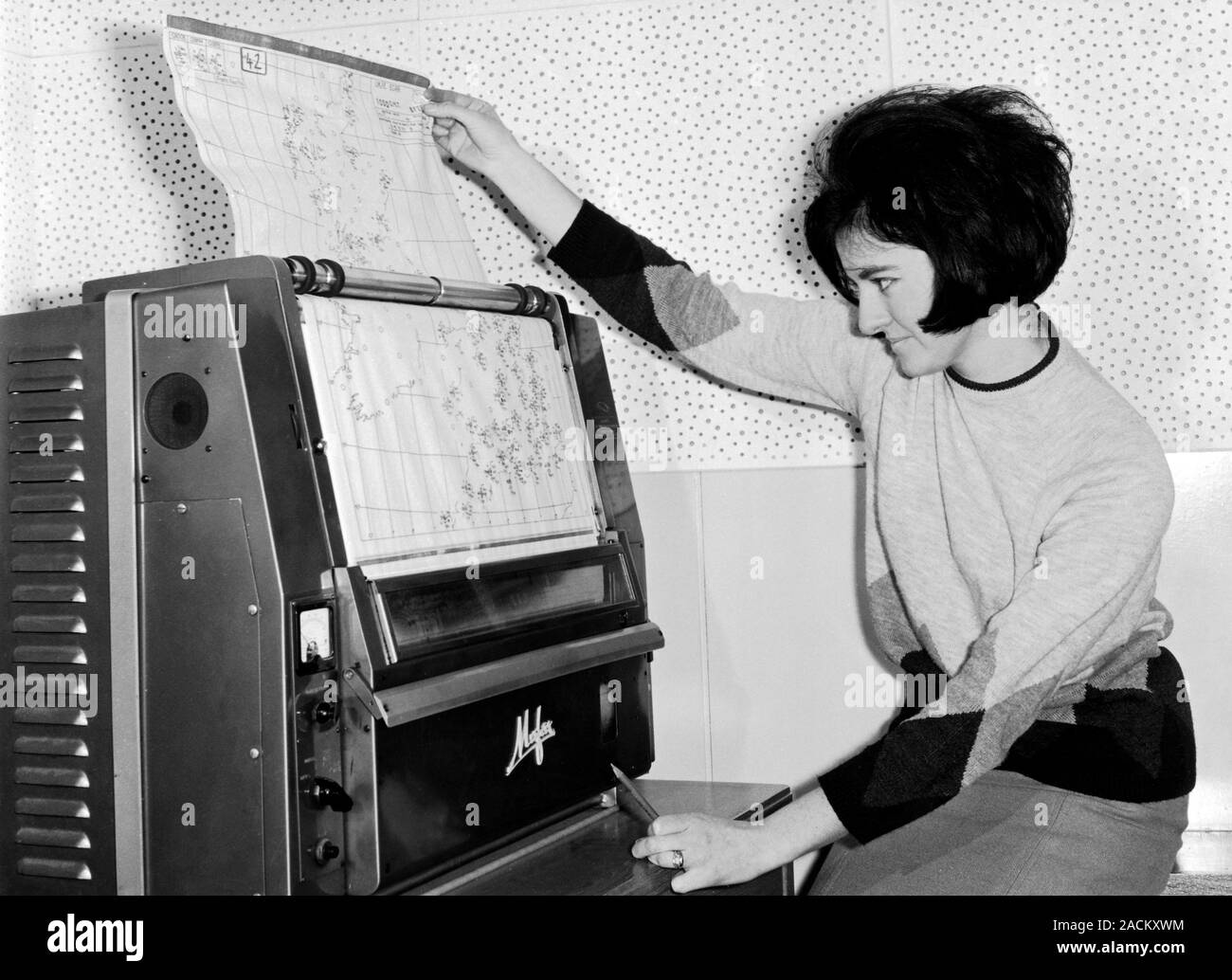 Weather chart transmission. Met Office employee using a Mufax machine ...