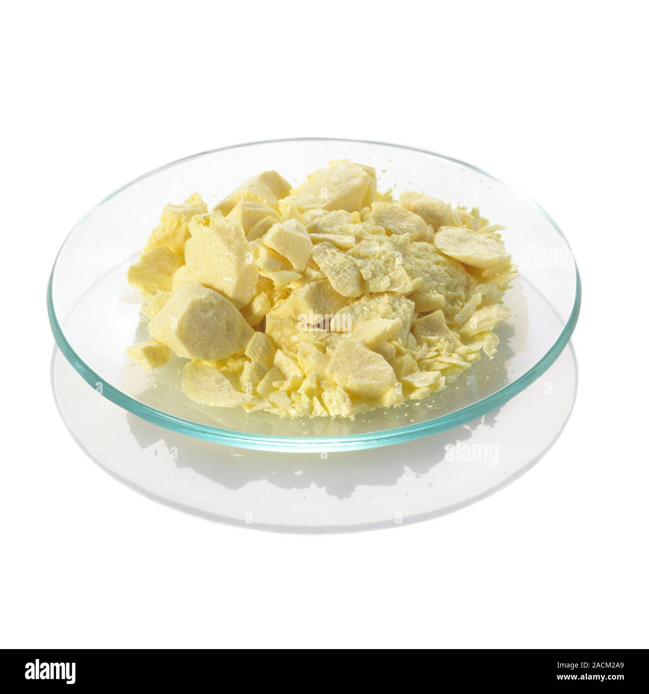 Sulphur. Sample of sulphur (S) on a watch glass. Sulphur is a reactive ...