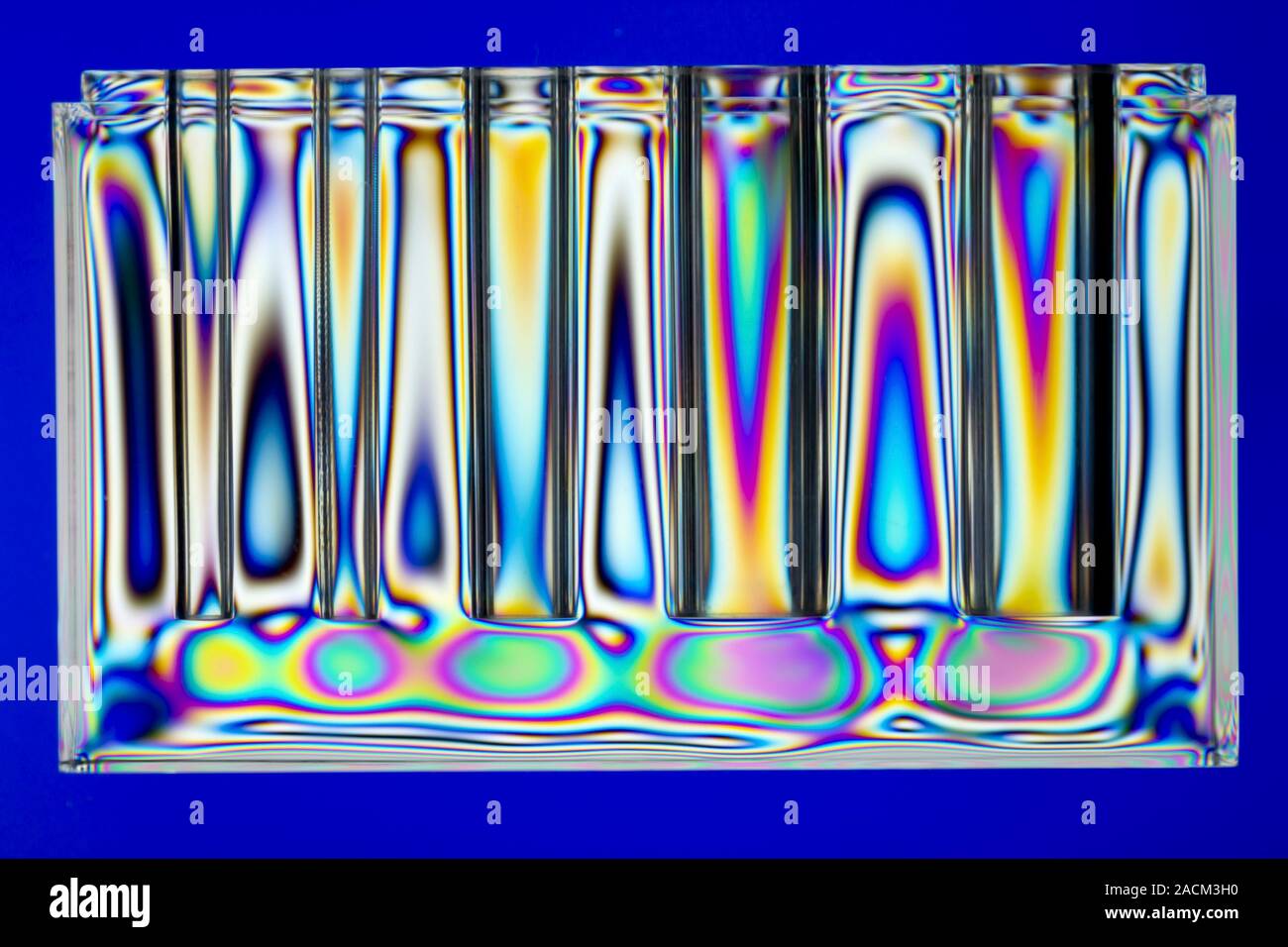 Coloured light interference pattern of plastic laboratory glasses. When photographed through ...