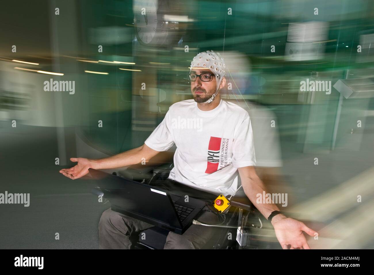 Thought-controlled wheelchair. Researcher testing a brain-machine ...