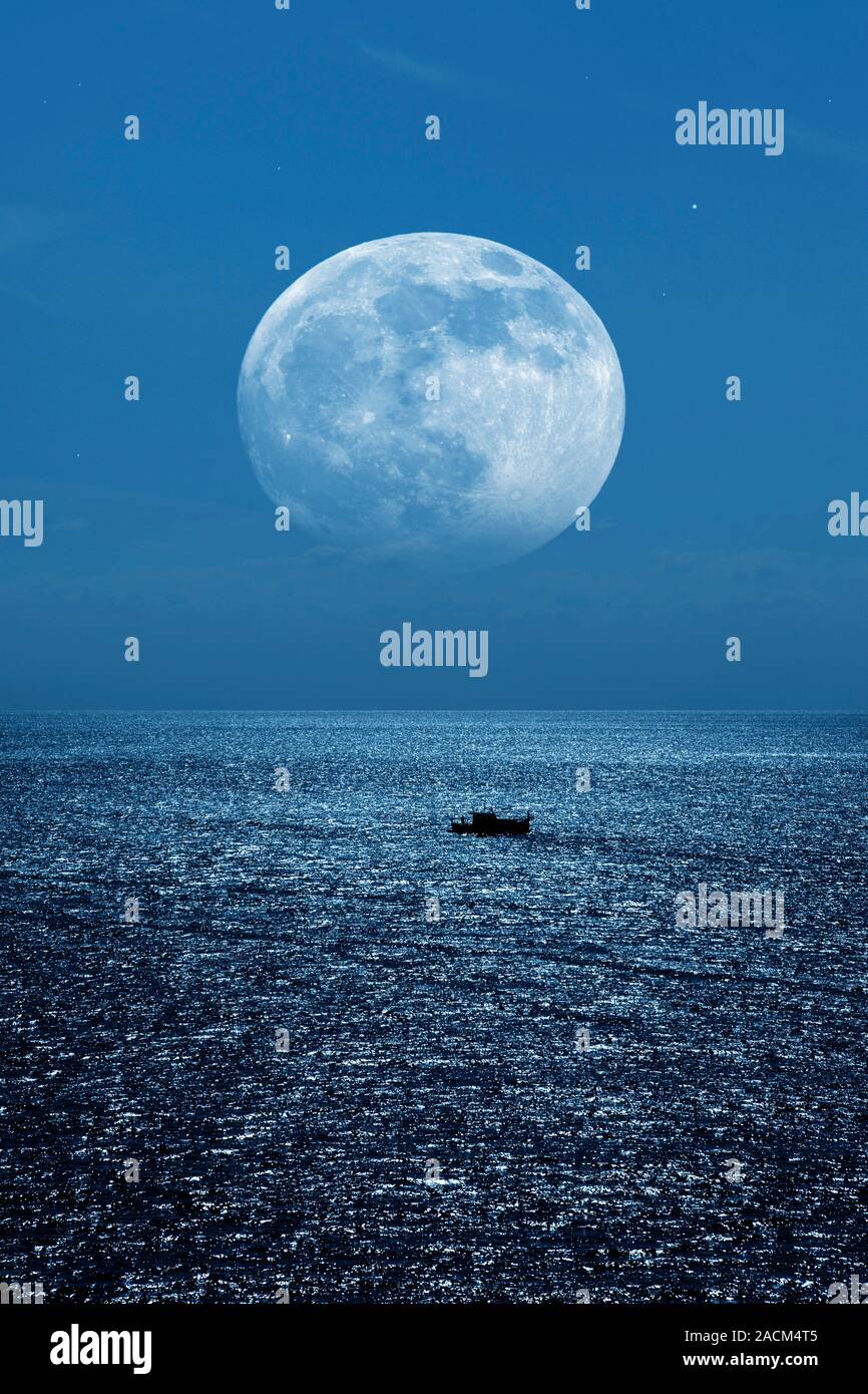 Full Moon rising over the sea and a boat. The lunar surface includes ...