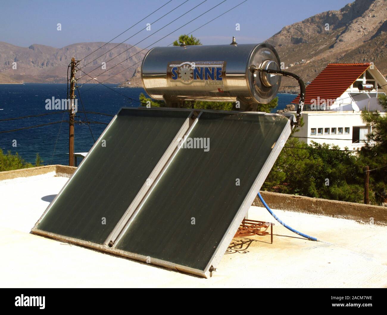 Solar water heater on a rooftop. The panels (black) are connected to a ...