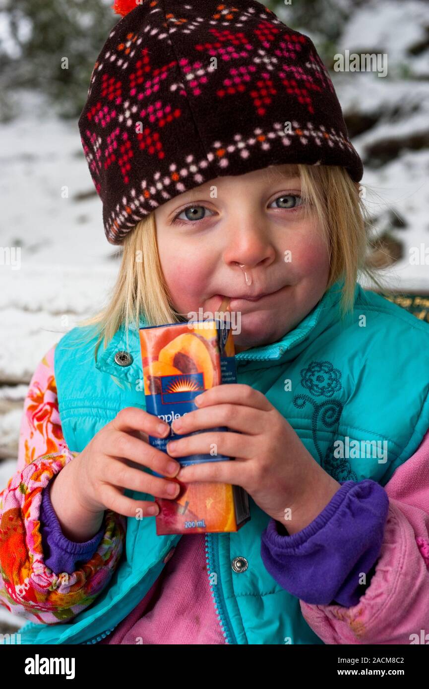 Girl with a runny nose drinking from a juice box Stock Photo - Alamy