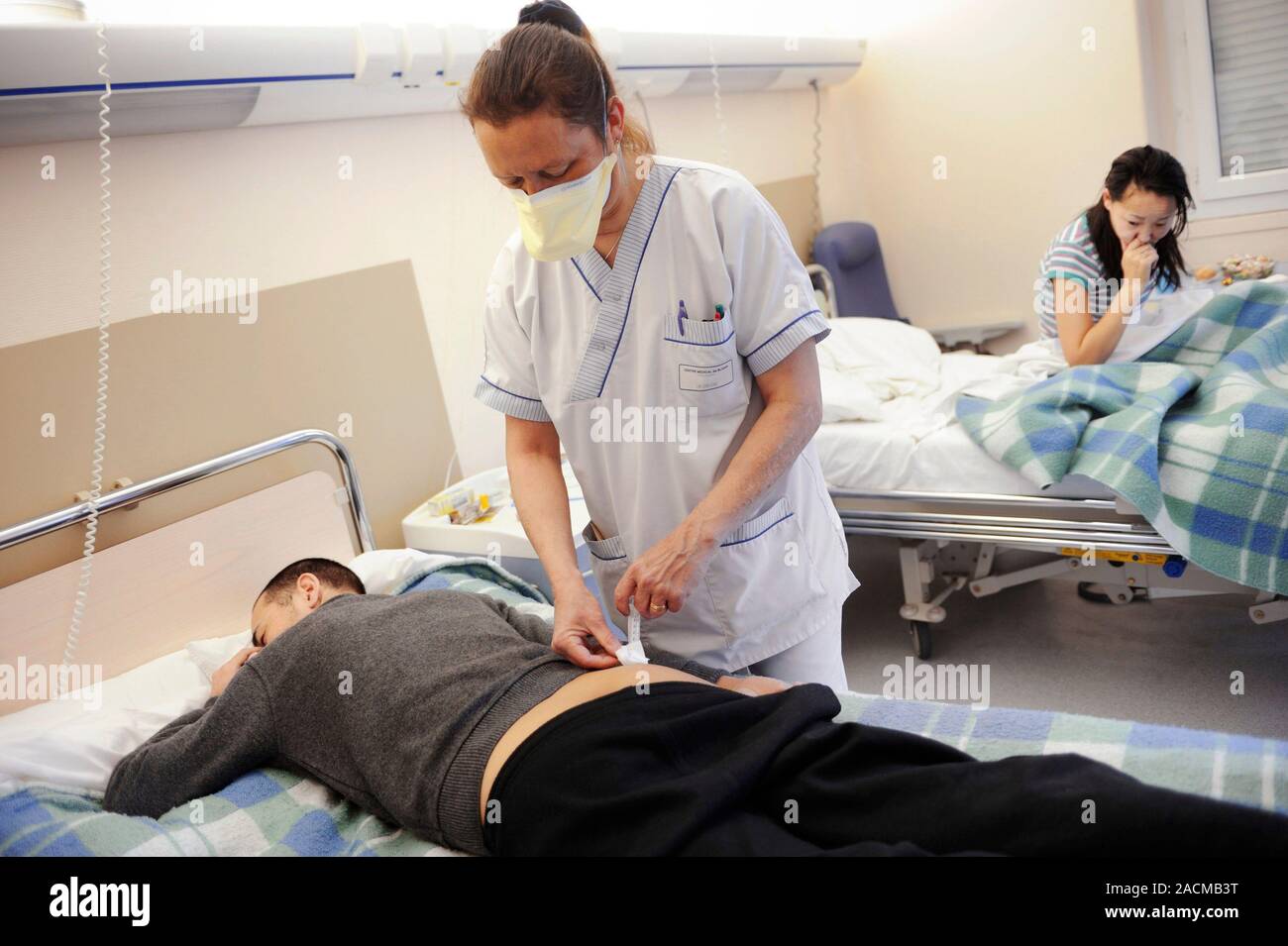 Tuberculosis clinic. Male patient receiving an intramuscular injection ...