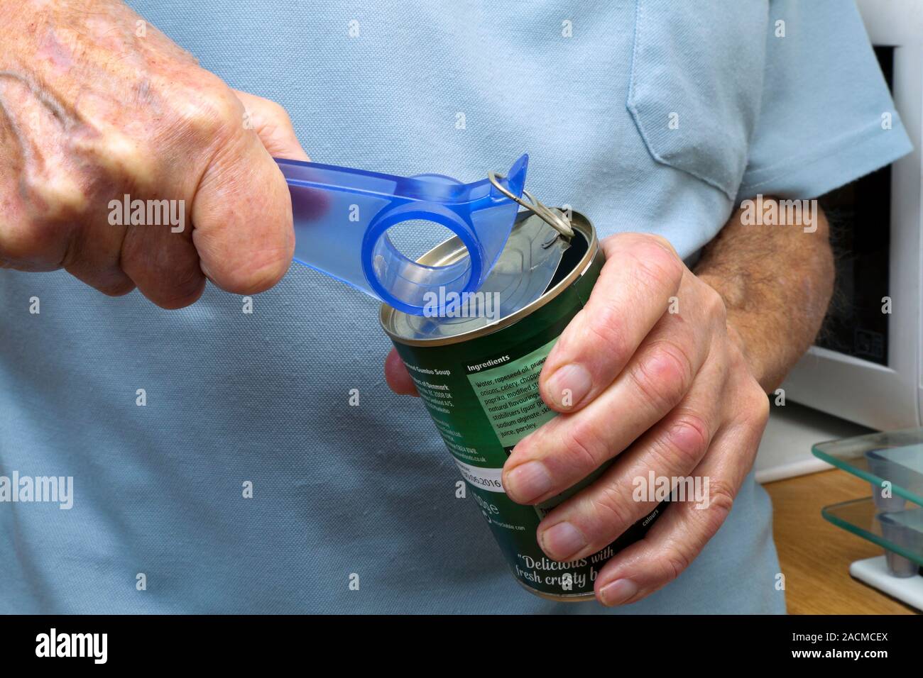 Elderly man opening a tin. Hands of an elderly man who is using a ...
