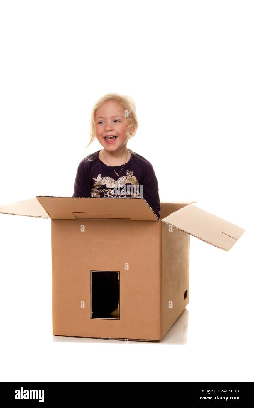 Child in cardboard box. It's in the box with the move Stock Photo - Alamy