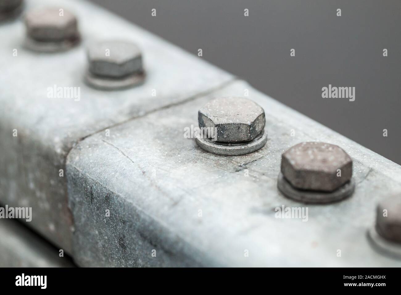 Abstract industrial background with gray bolts in a row, close-up photo ...