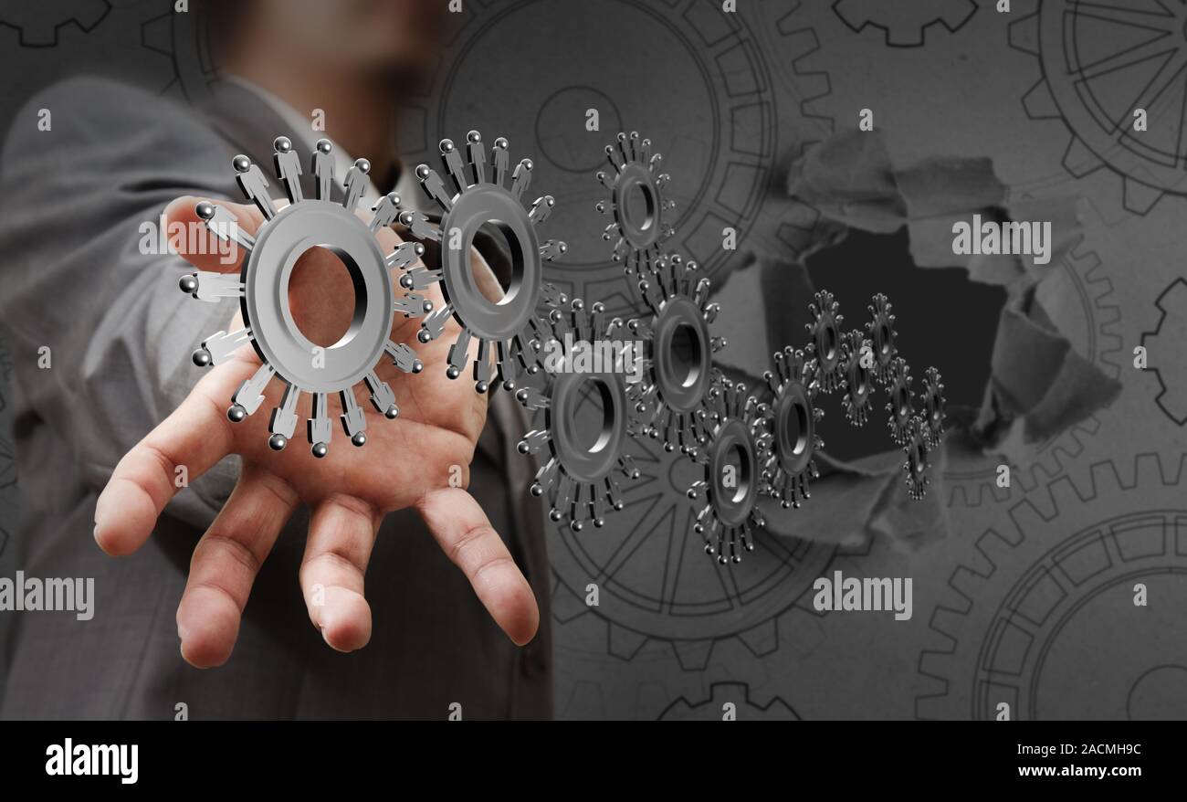 Businessman hand shows people cogs Stock Photo - Alamy