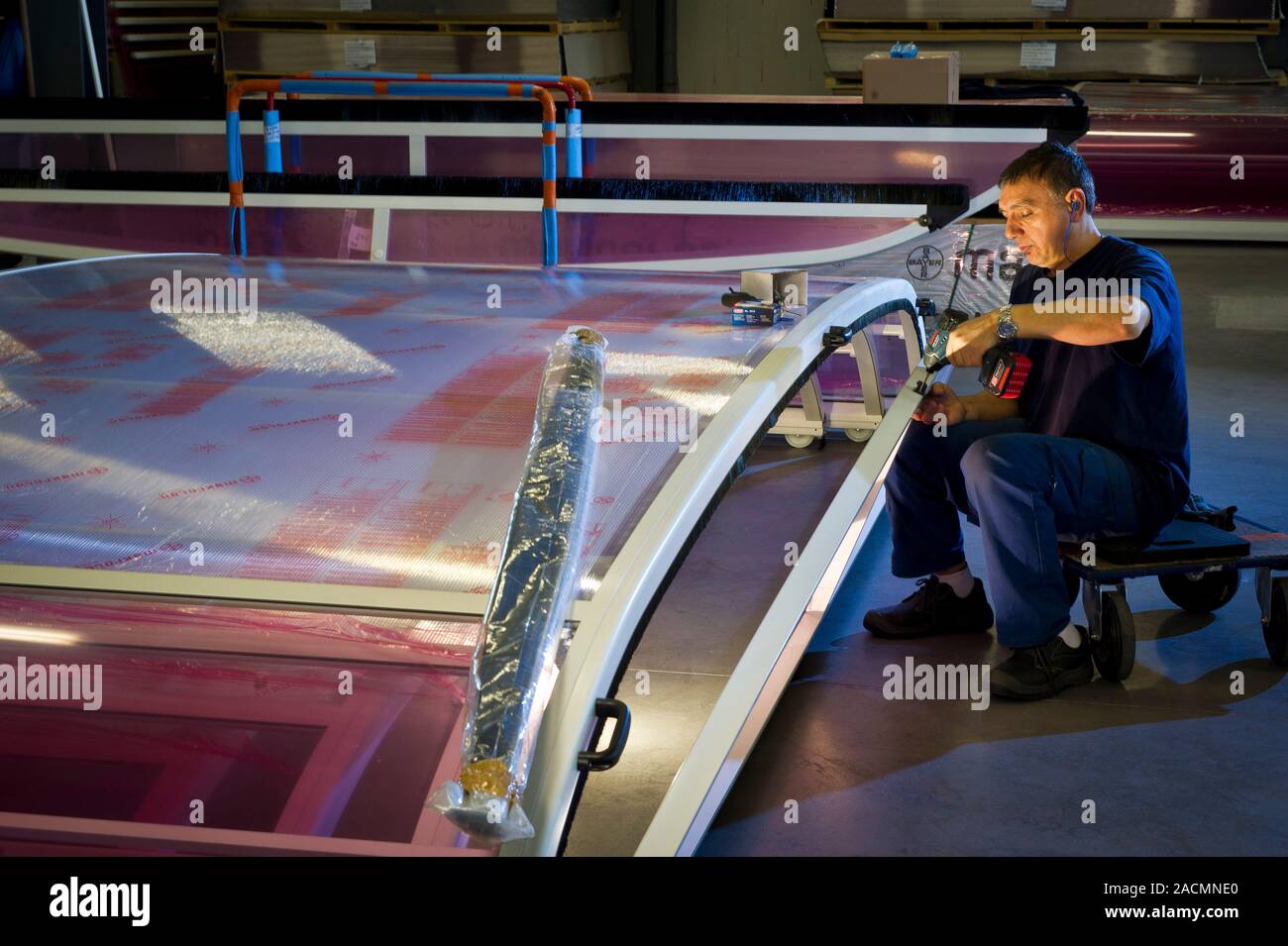 Swimming pool manufacturing. Worker assembling sections of swimming ...