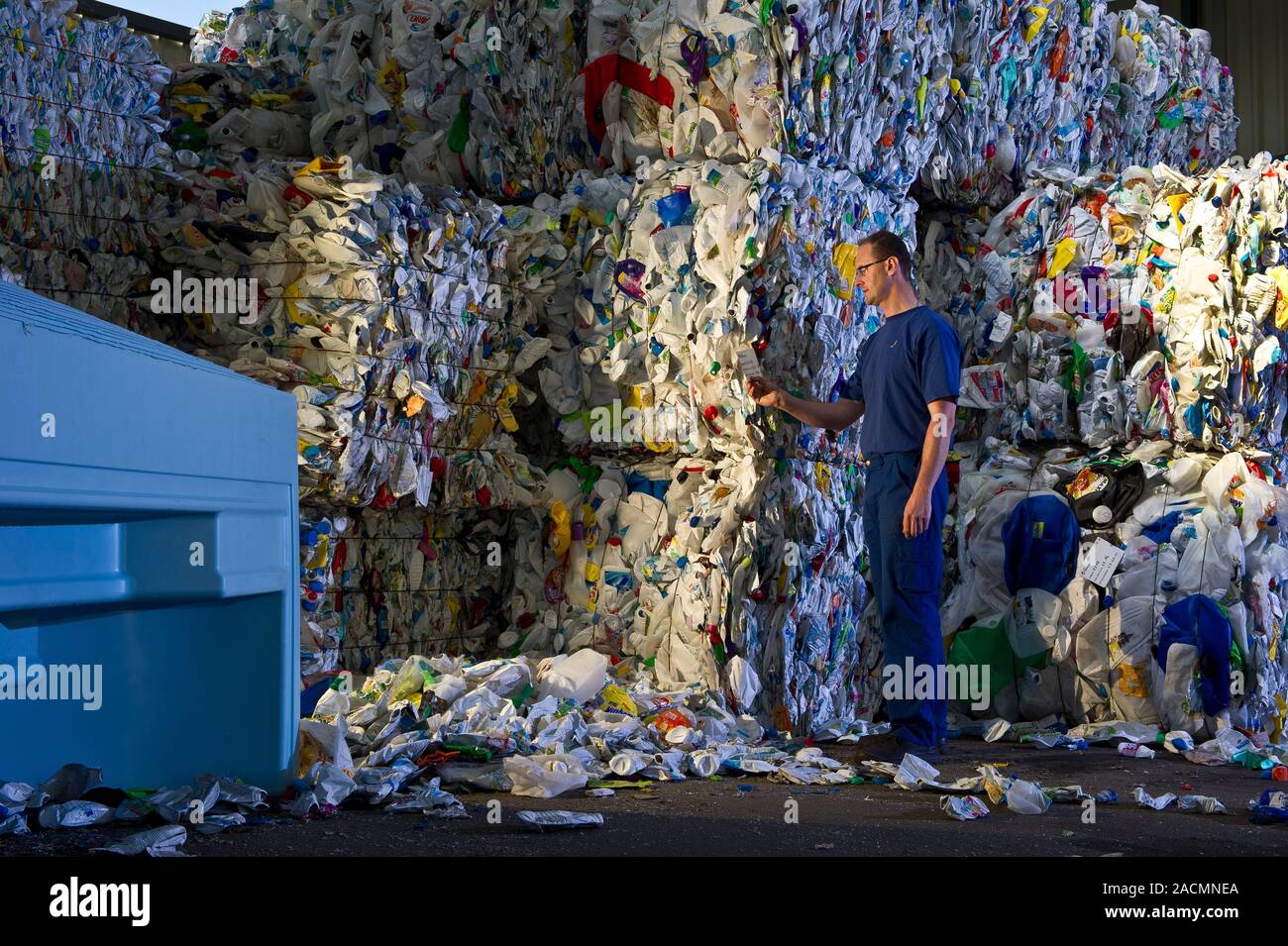 Swimming pool manufacturing. Factory worker next to stacks of discarded ...