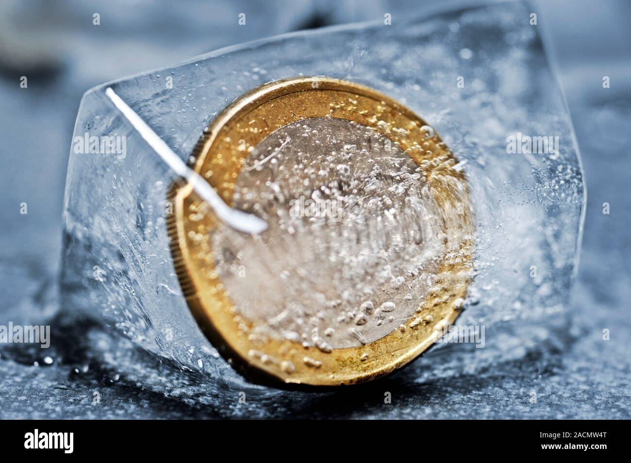 Frozen bank account, conceptual image. One Euro coin frozen in a block ...