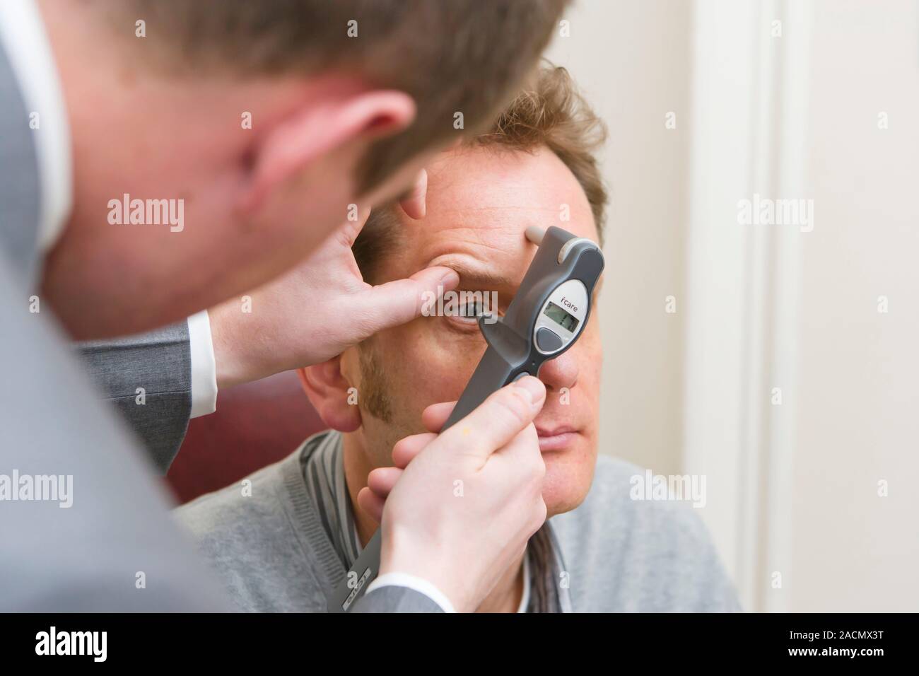 A tonometer being used to measures pressure in the eye, which tests for ...