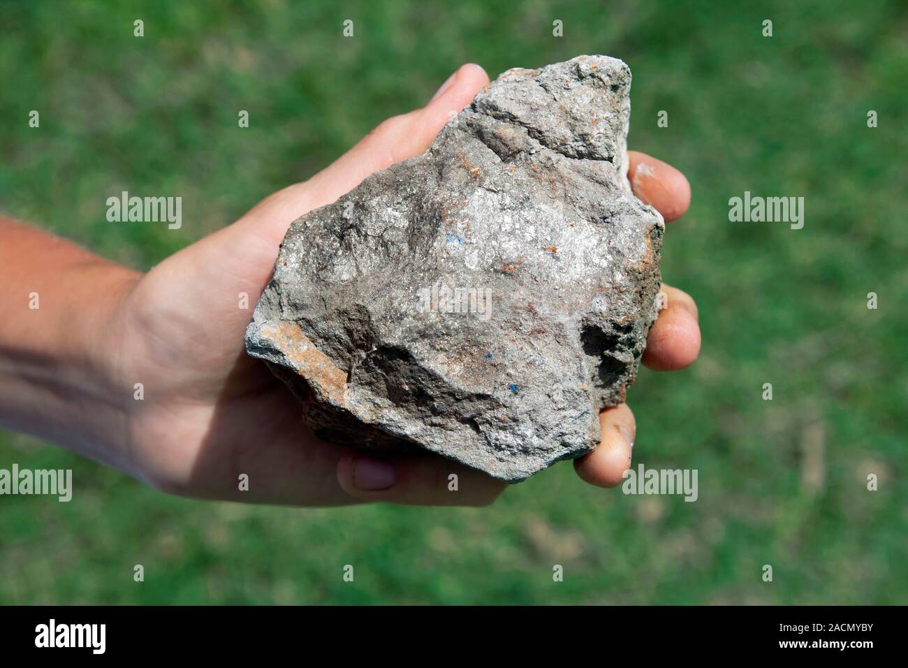 Volcanogenic massive sulphide ore deposit. Woman holding rock from a ...