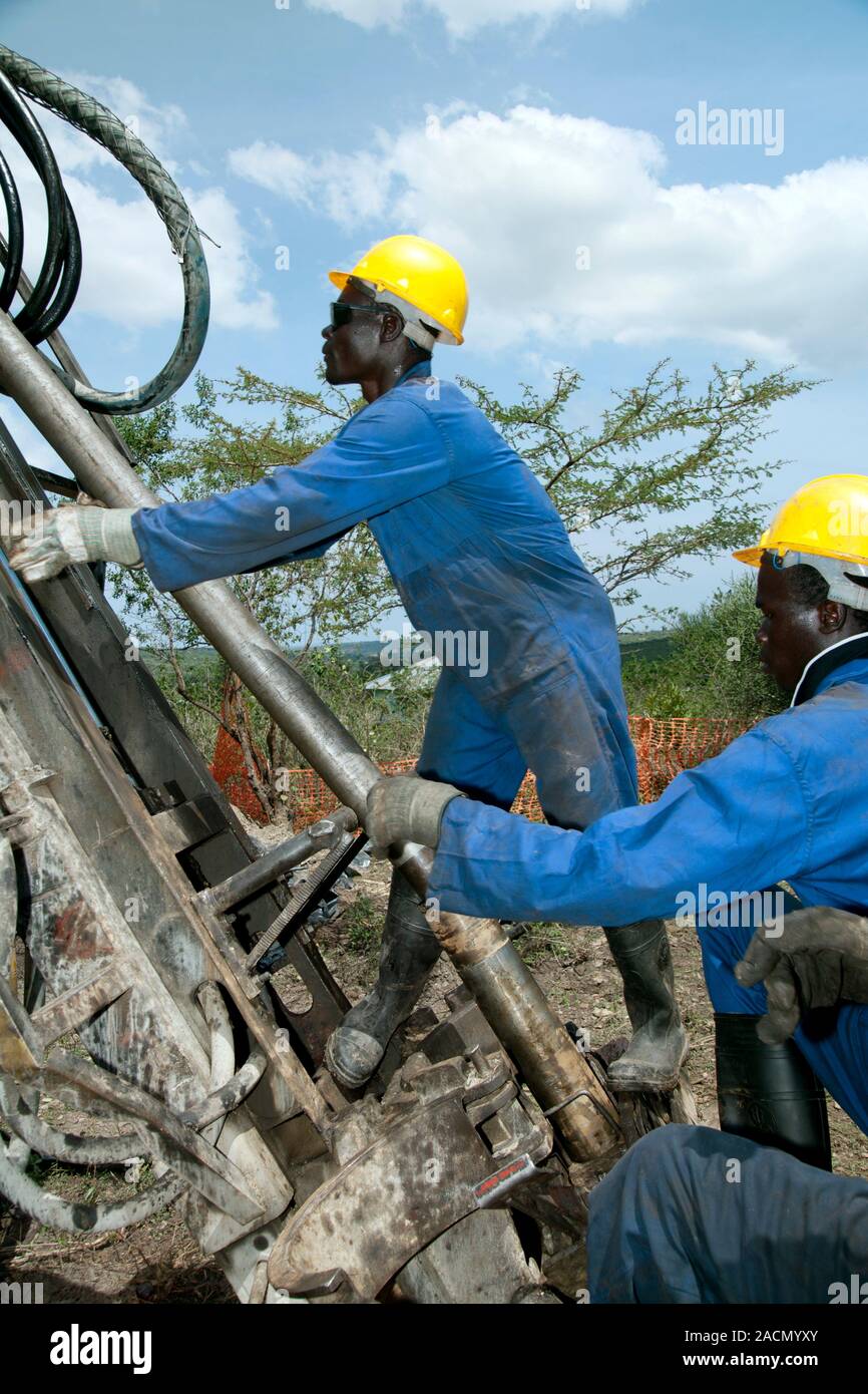 Mineral exploration drilling. Workers removing the drill rods from a ...