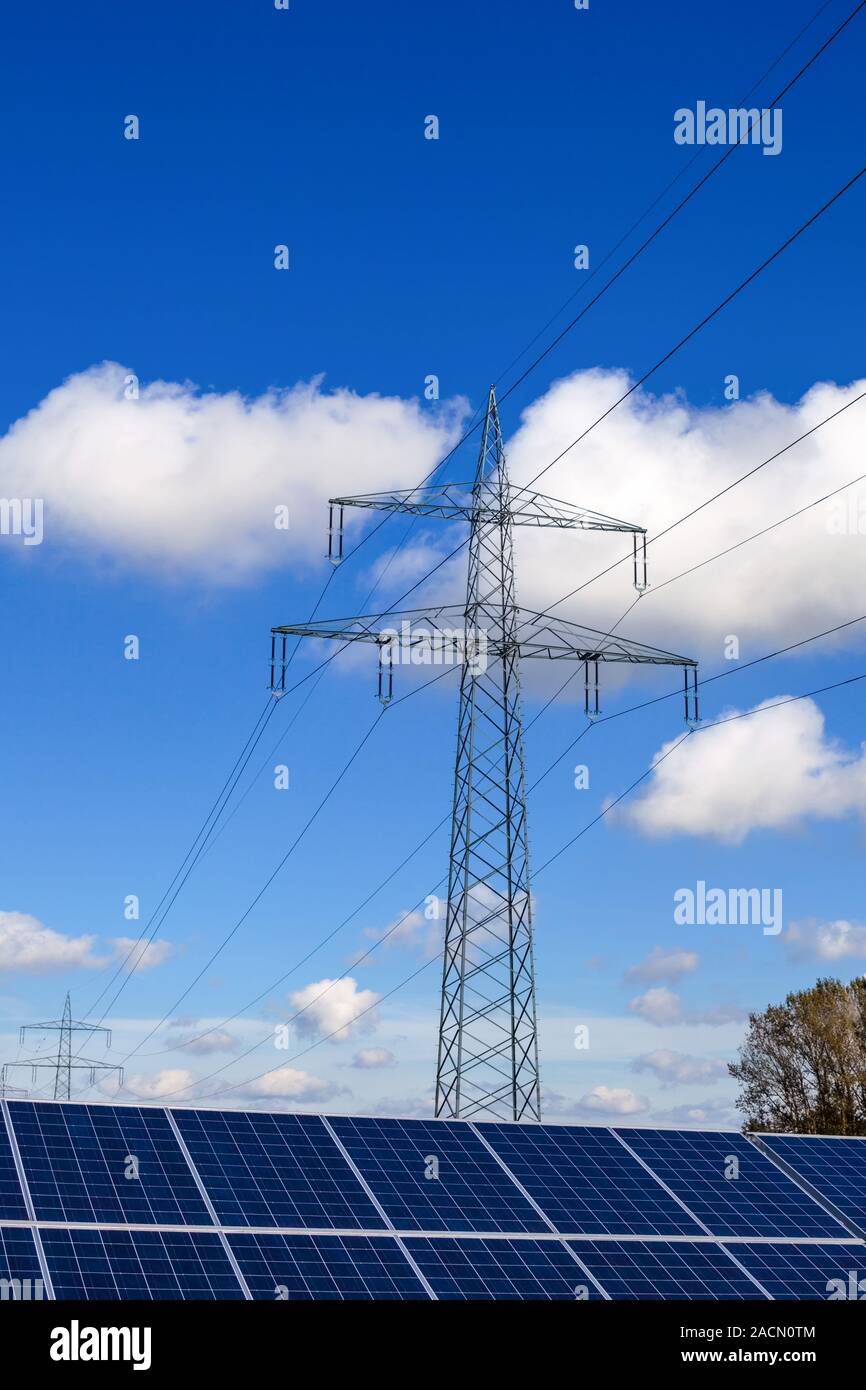 High voltage pylons and solar cells Stock Photo - Alamy