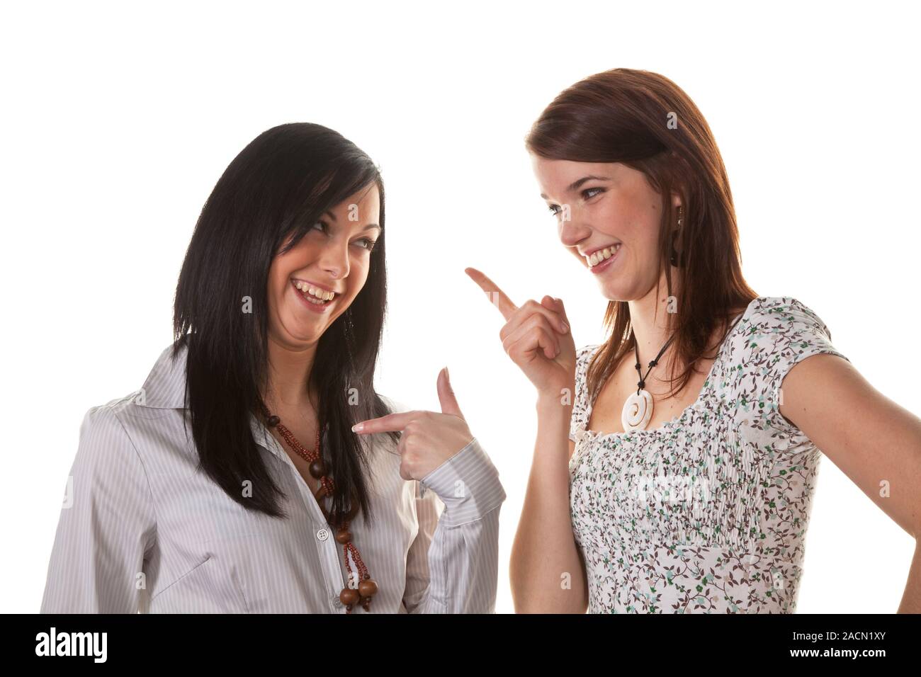 Two young women whispering together Stock Photo - Alamy