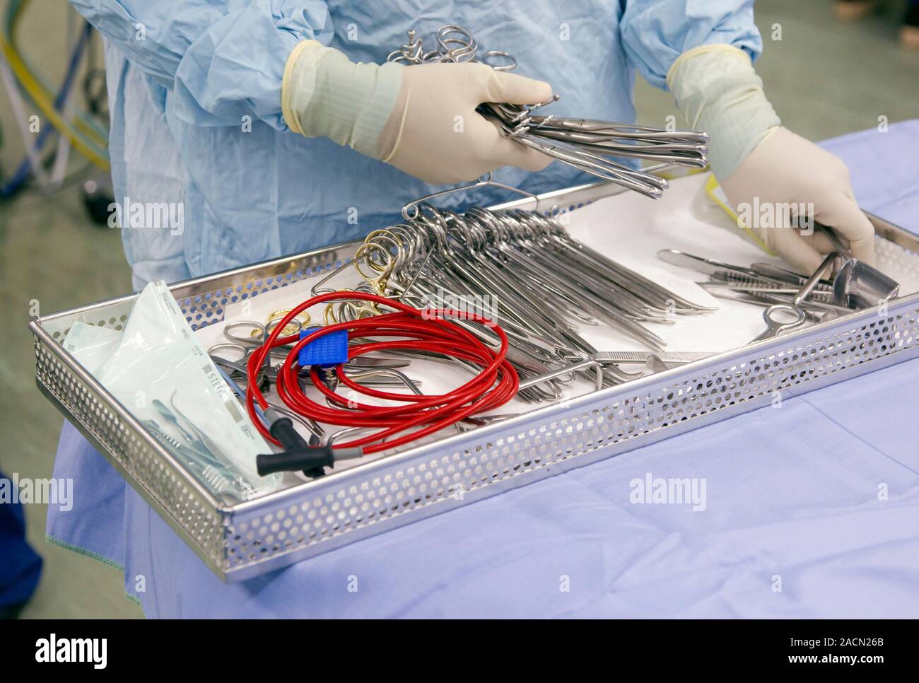 Surgical tools. Surgical team member laying out equipment ready for a ...
