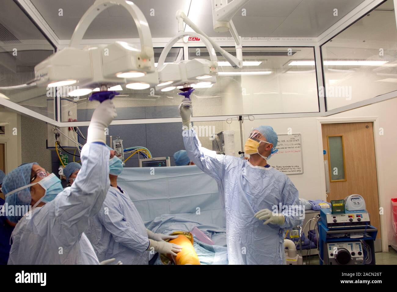 Hip replacement surgery. Surgical team adjusting lights in theatre ...