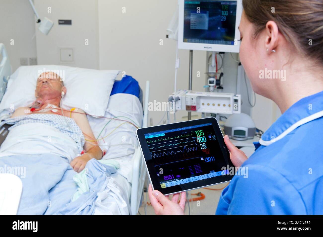 Nurse using a portable touch-screen tablet computer to check a patient ...