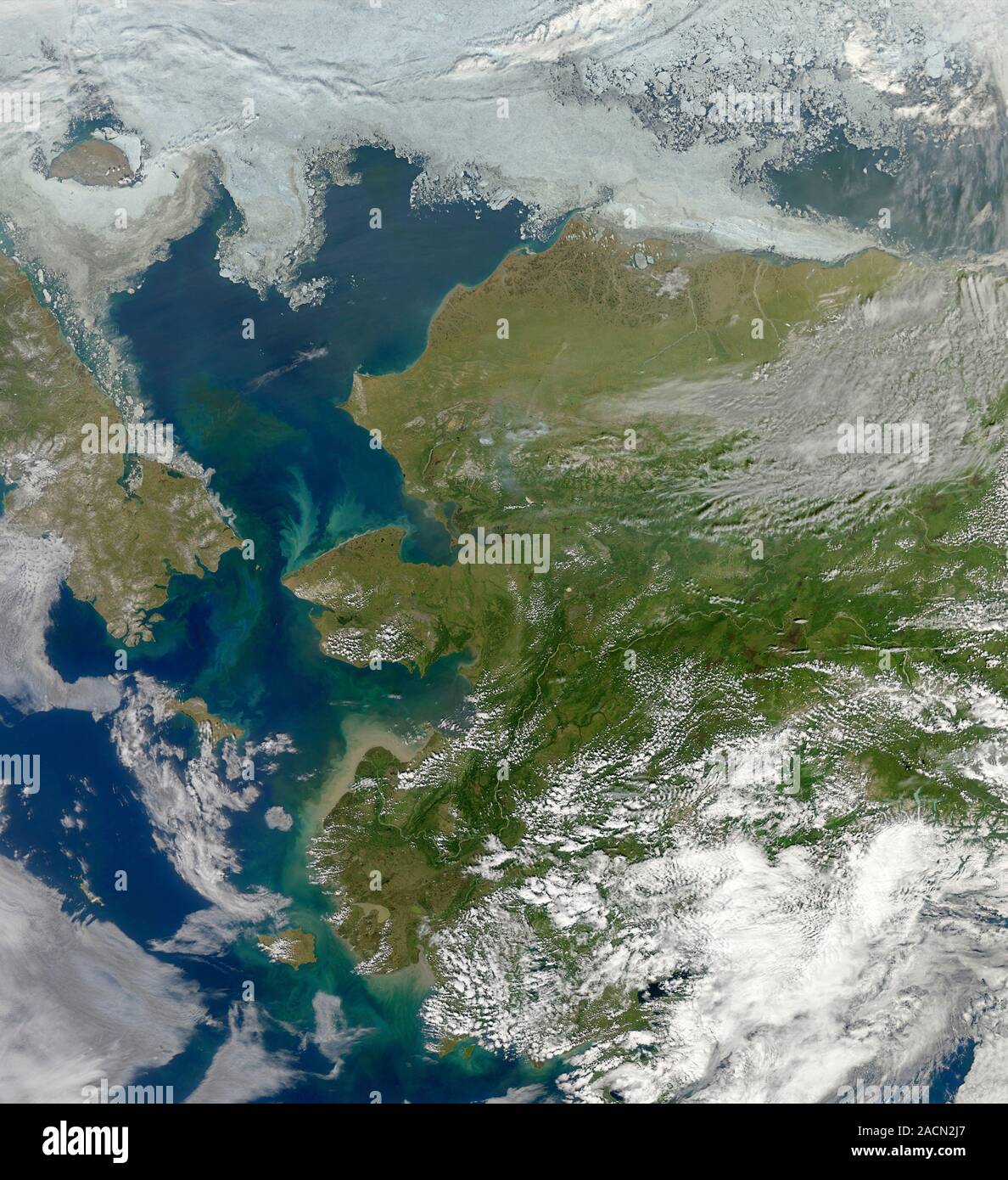 Bering Strait, satellite image. North is at top. Clouds are white and ...