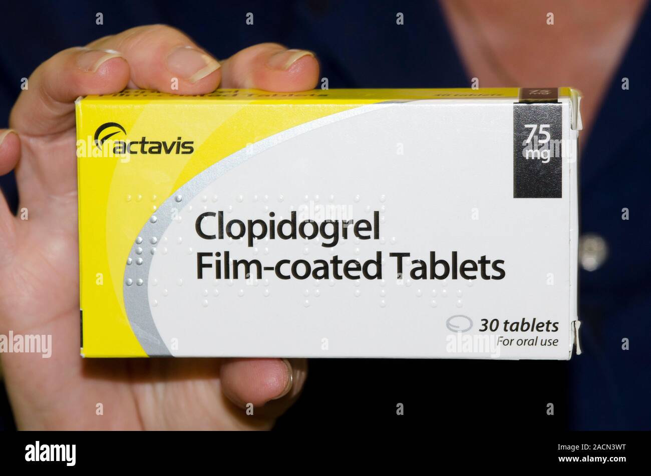 Hand holding a pack of Clopidogrel tablets, an anti-platelet drug used ...