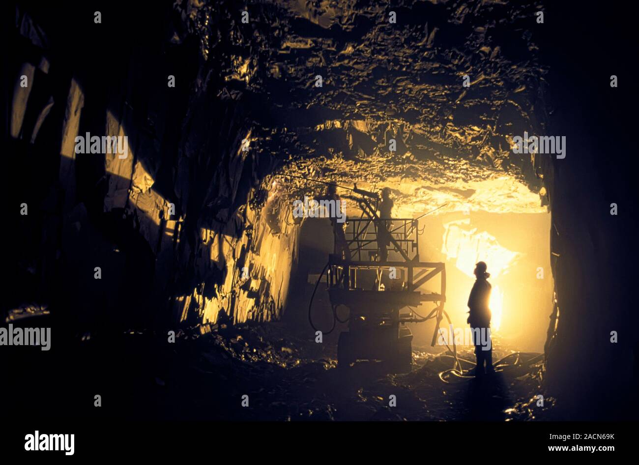 Slate mining. Workers drilling holes in the rockface of an underground ...