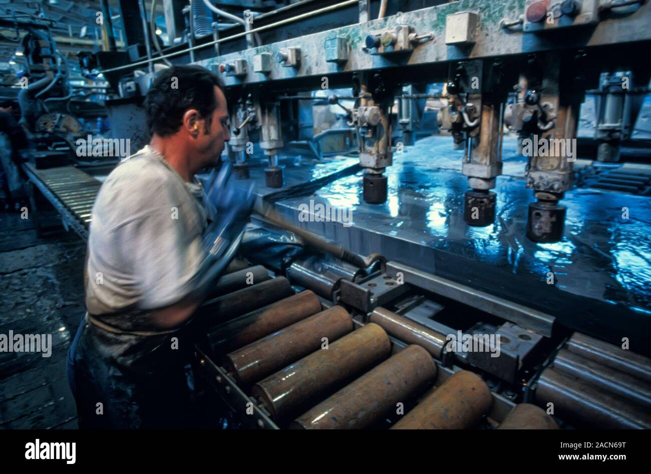 Slate mining. Worker at a slate mill sawing slabs of slate into smaller ...