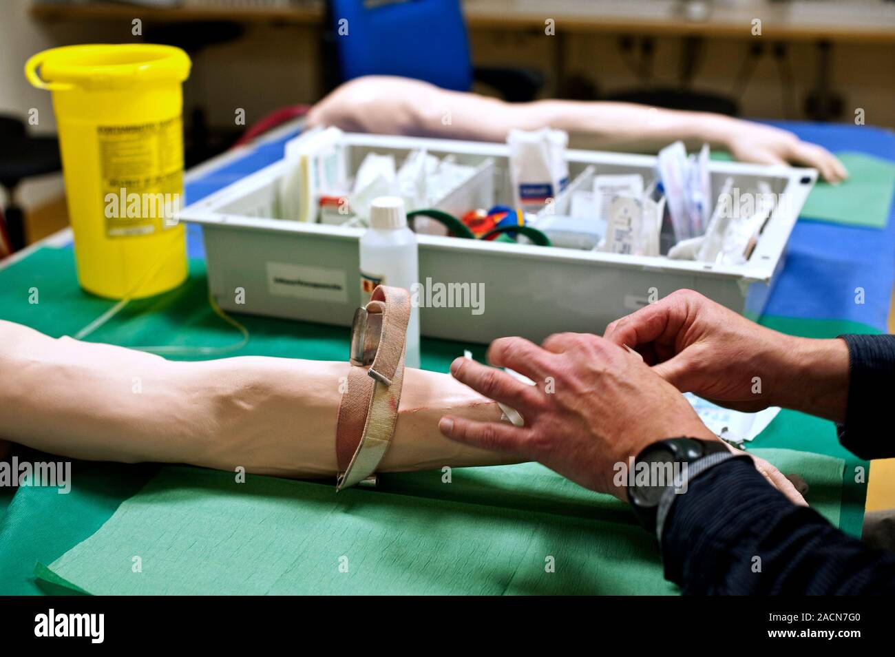 Cannula training. Close-up of a person using a dummy arm to practice ...