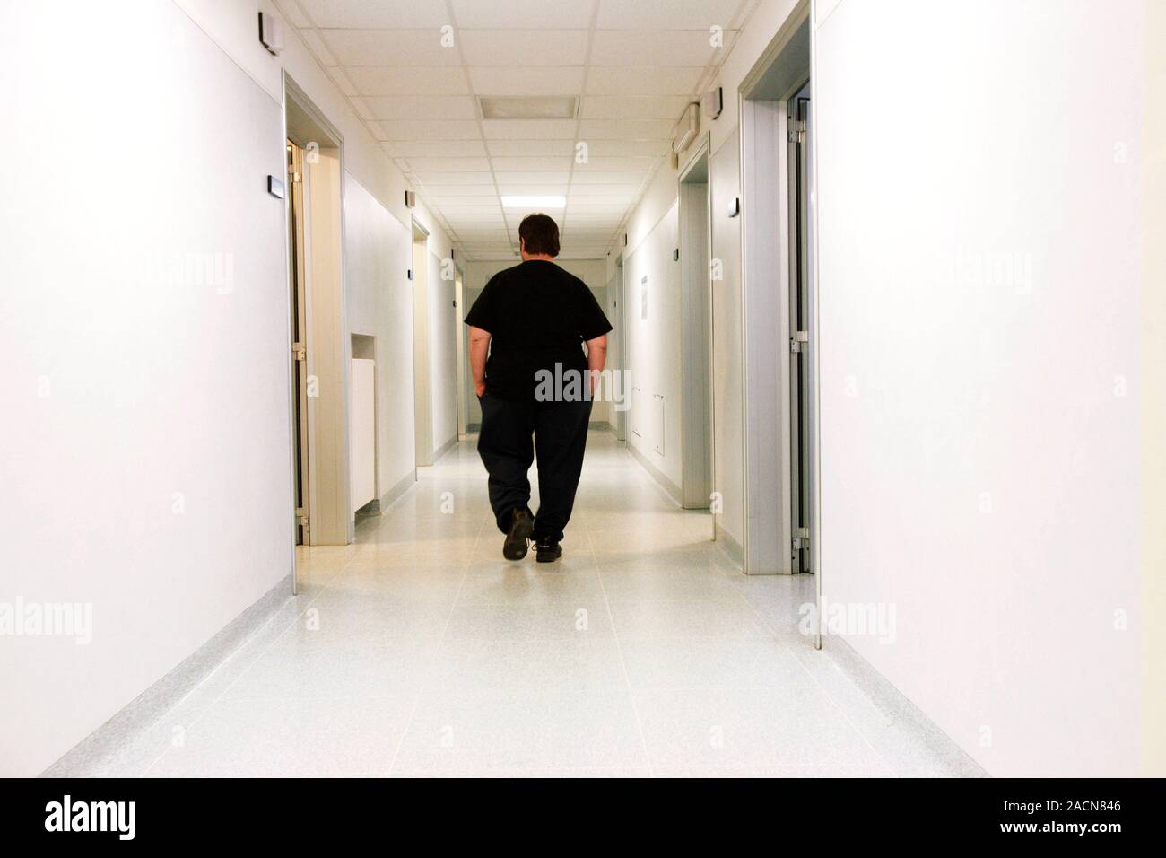 Obesity clinic. Male patient walking along a corridor Stock Photo - Alamy