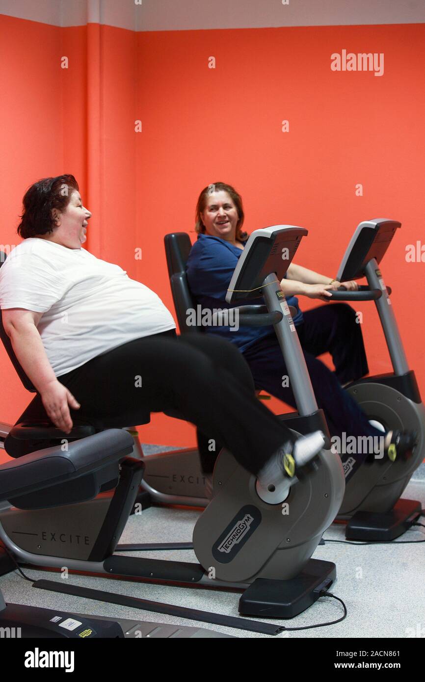 Obesity clinic. Female patients using an exercise bike Stock Photo - Alamy