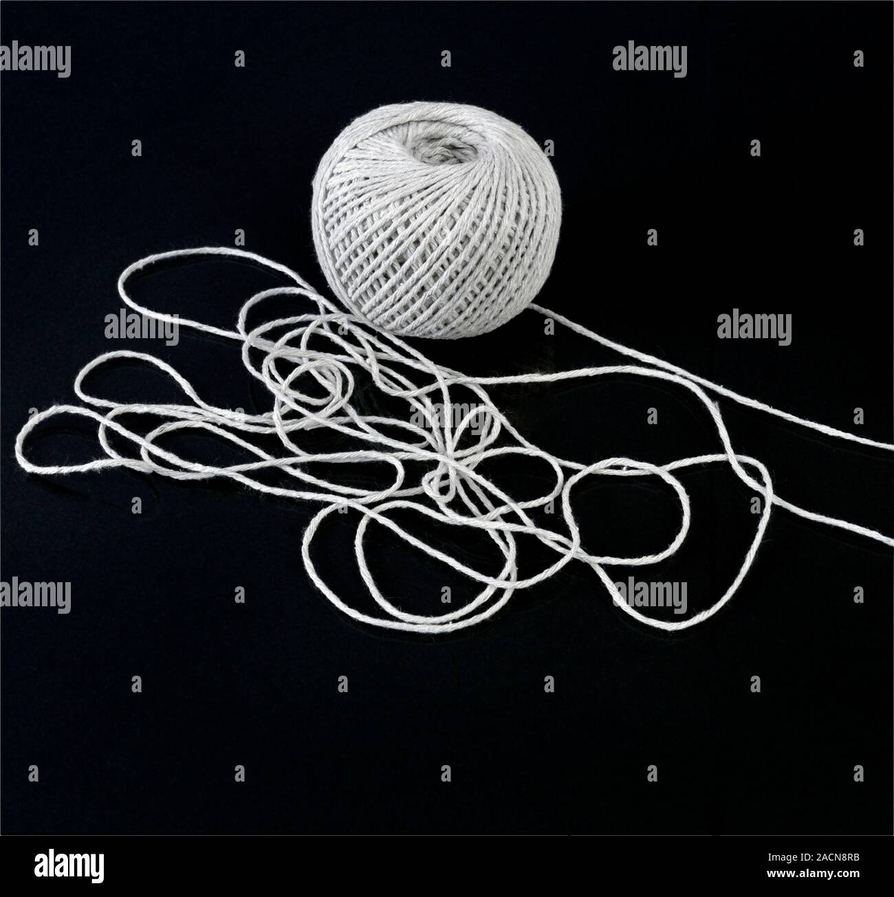 Ball of string partially unwound Stock Photo - Alamy
