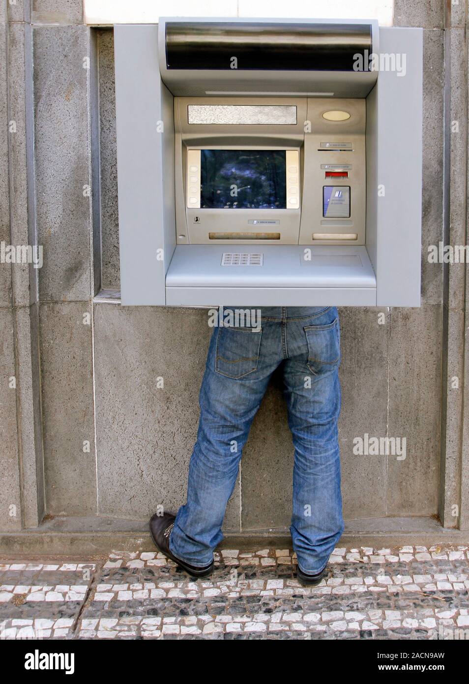 Cash machine maintenance. Engineer fixing a cash-dispensing machine ...