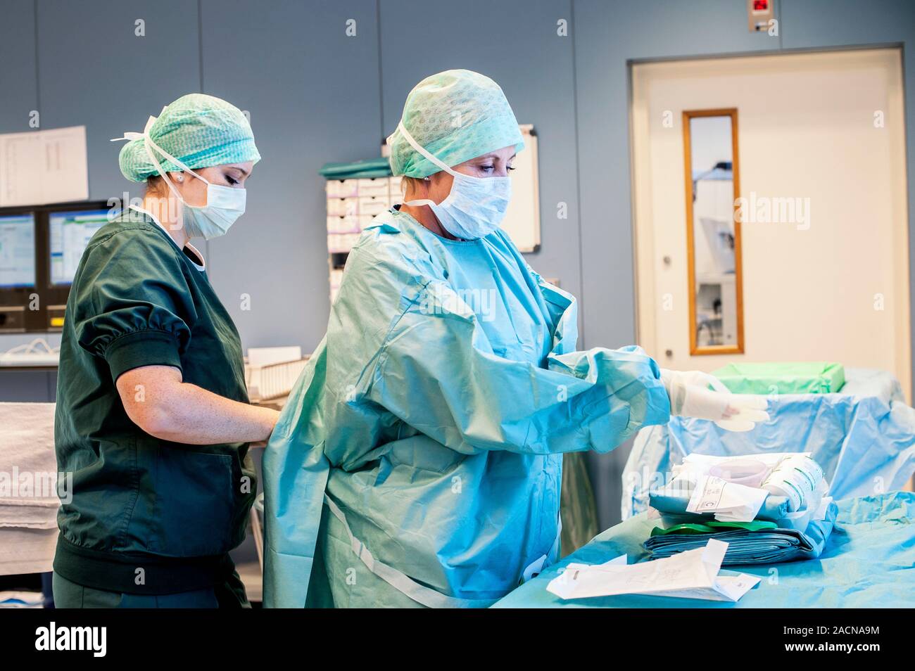 Surgical staff preparing for surgery. Surgical staff members dressing ...