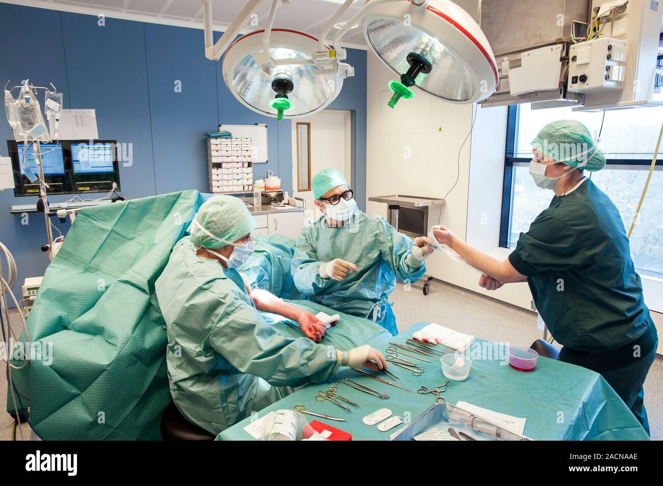 Elbow surgery. Surgeons performing an operation to treat cubital tunnel ...