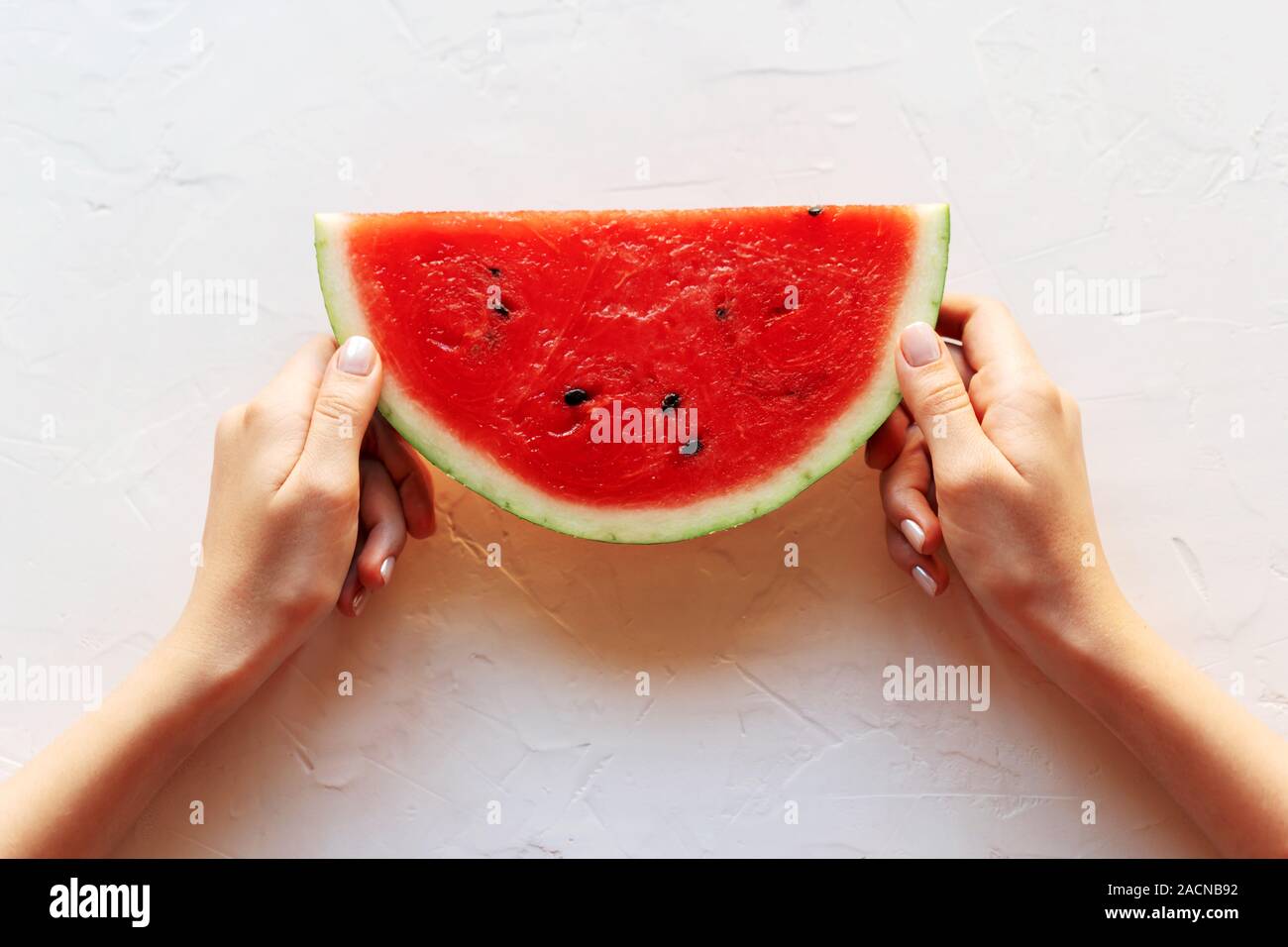 A slice of watermelon in female hands Stock Photo - Alamy