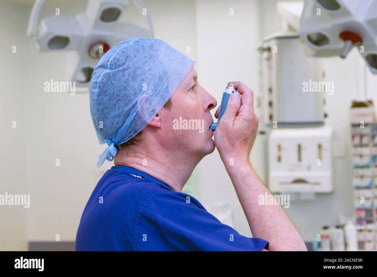 Asthma inhaler use. Surgeon using an inhaler to treat an asthma attack ...