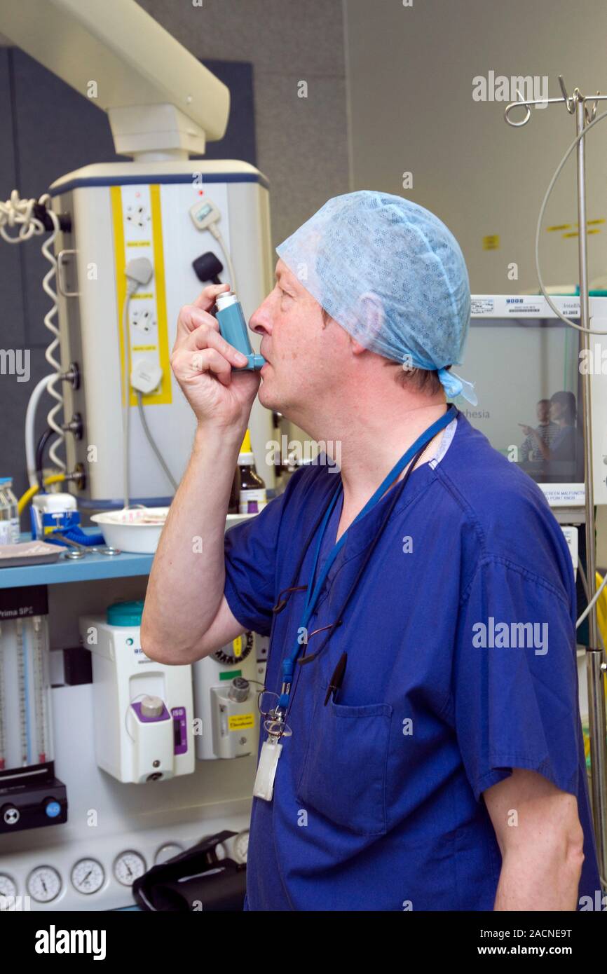 Asthma inhaler use. Surgeon using an inhaler to treat an asthma attack ...