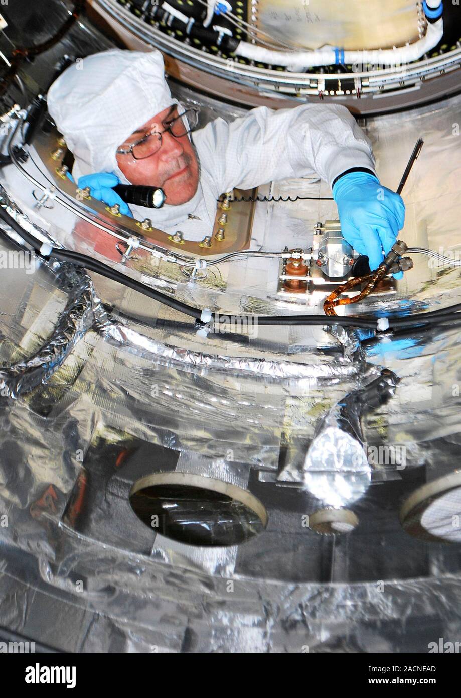 NuSTAR space telescope construction. Spacecraft technician performing ...