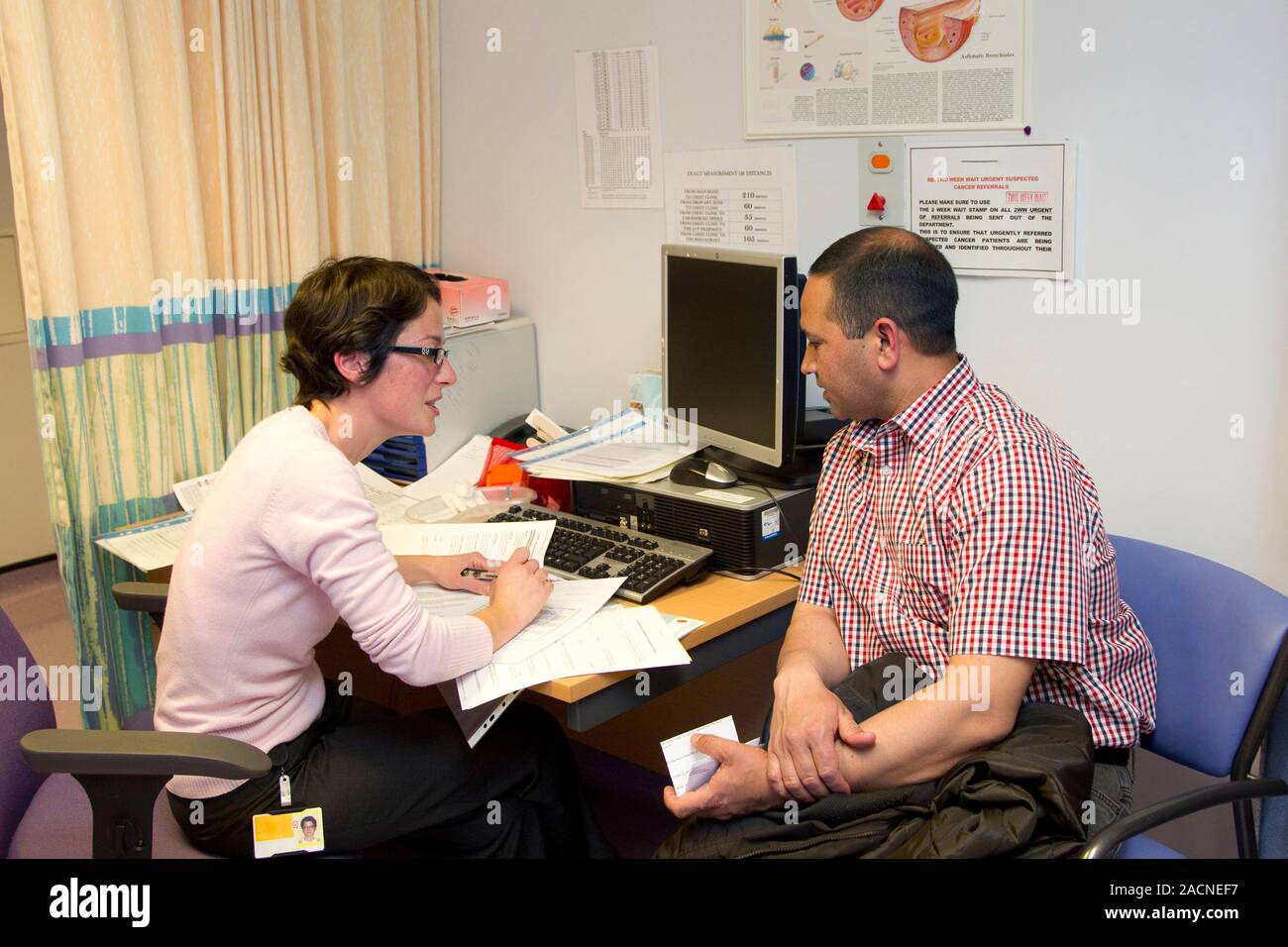 Tuberculosis (TB) clinic consultation. Doctor advising a patient at a ...