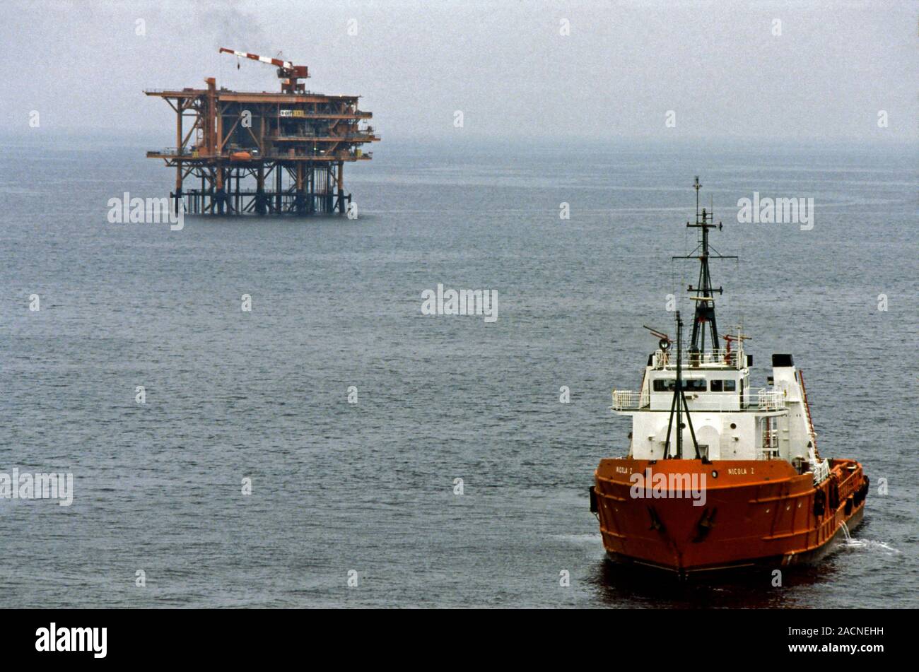 Oil rig and fire boat. View of an offshore oil drilling platform and a ...
