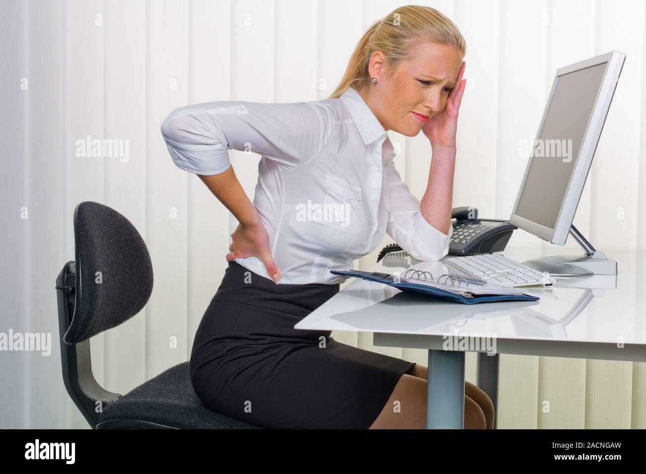 Women in the office with back pain Stock Photo - Alamy