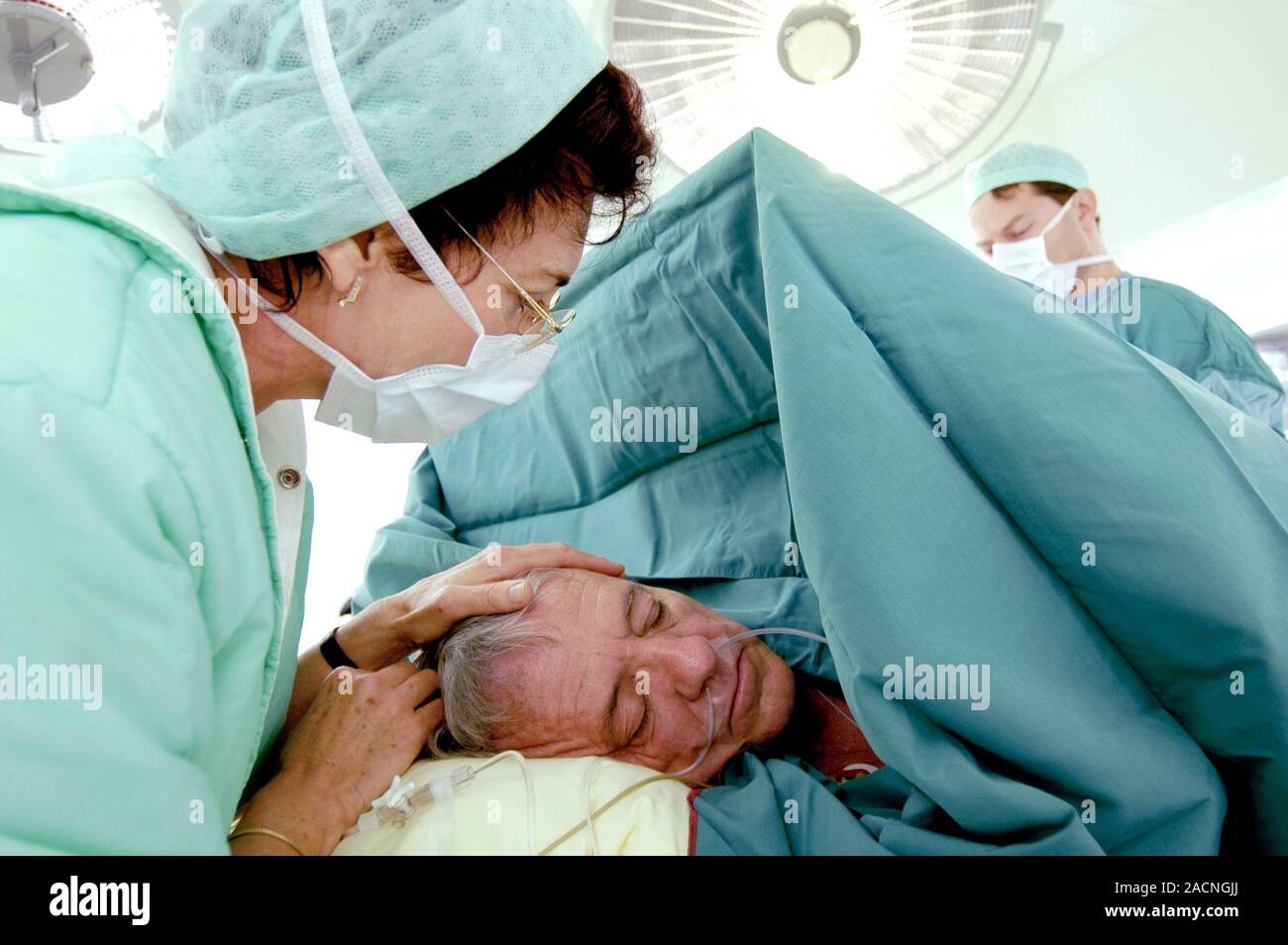 Hypnosis during surgery. Doctor (left) using hypnosis to 'anaesthetise ...