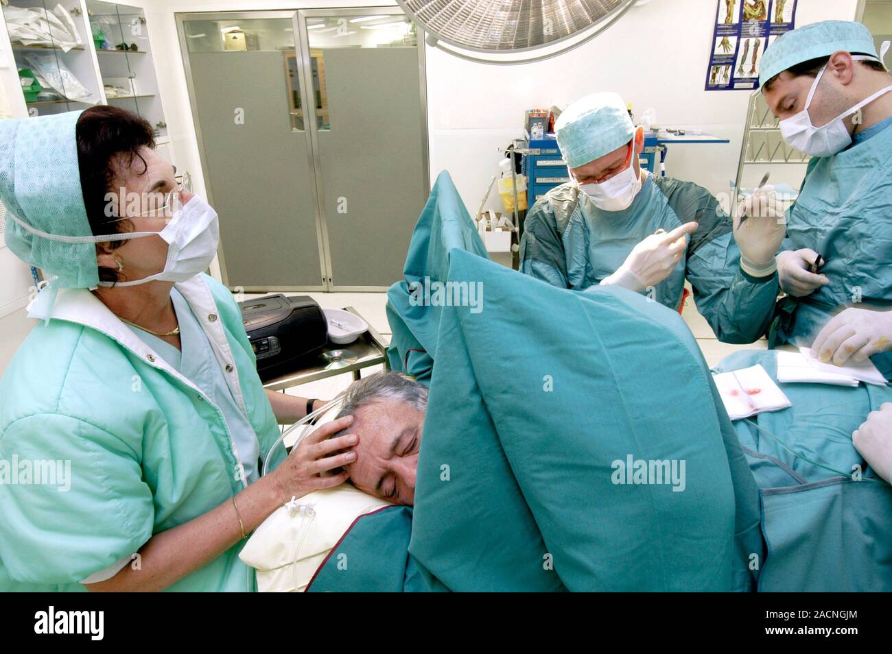 Hypnosis during surgery. Doctor (left) using hypnosis to 'anaesthetise ...