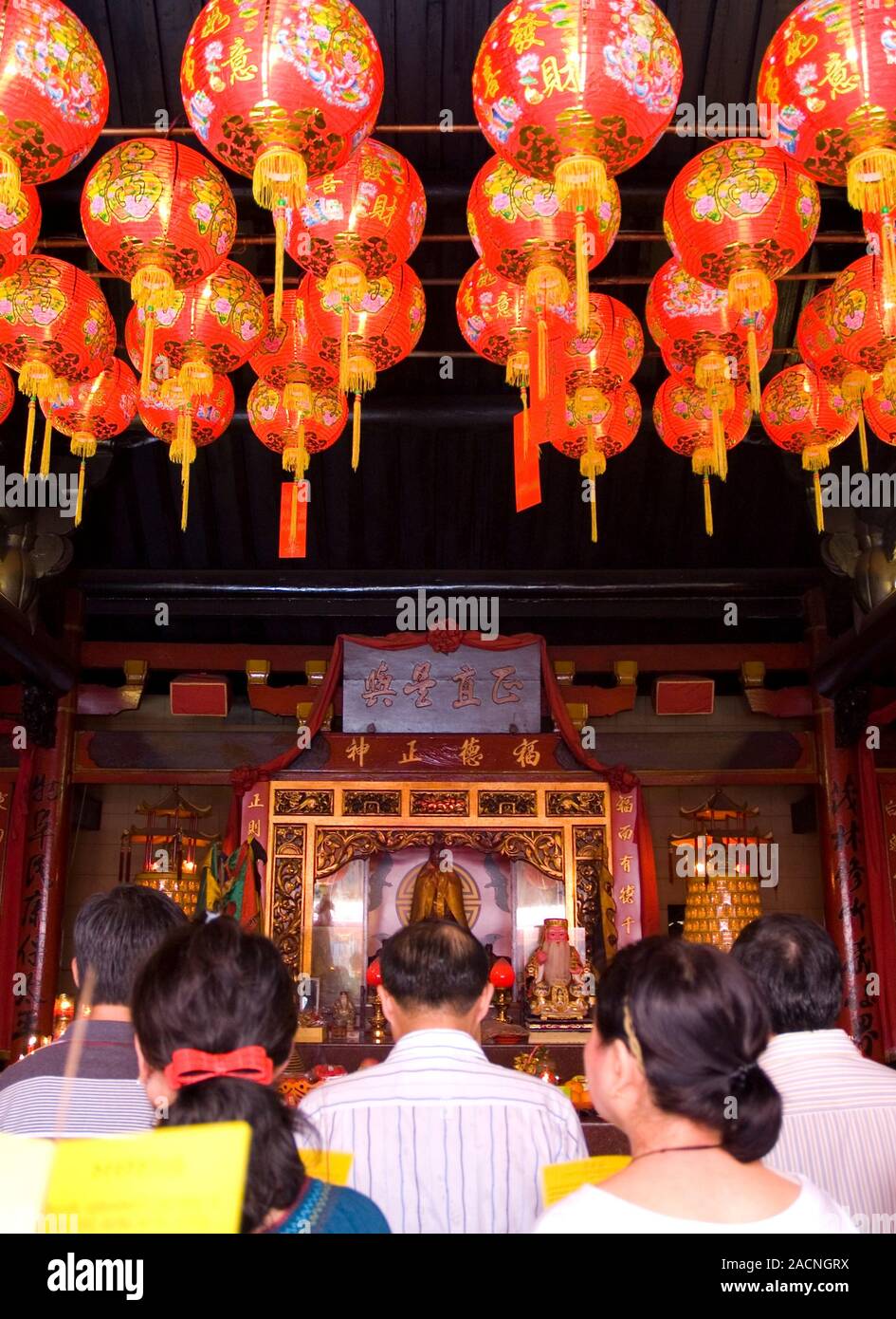 A group of Buddhist people pray together in a temple Stock Photo - Alamy