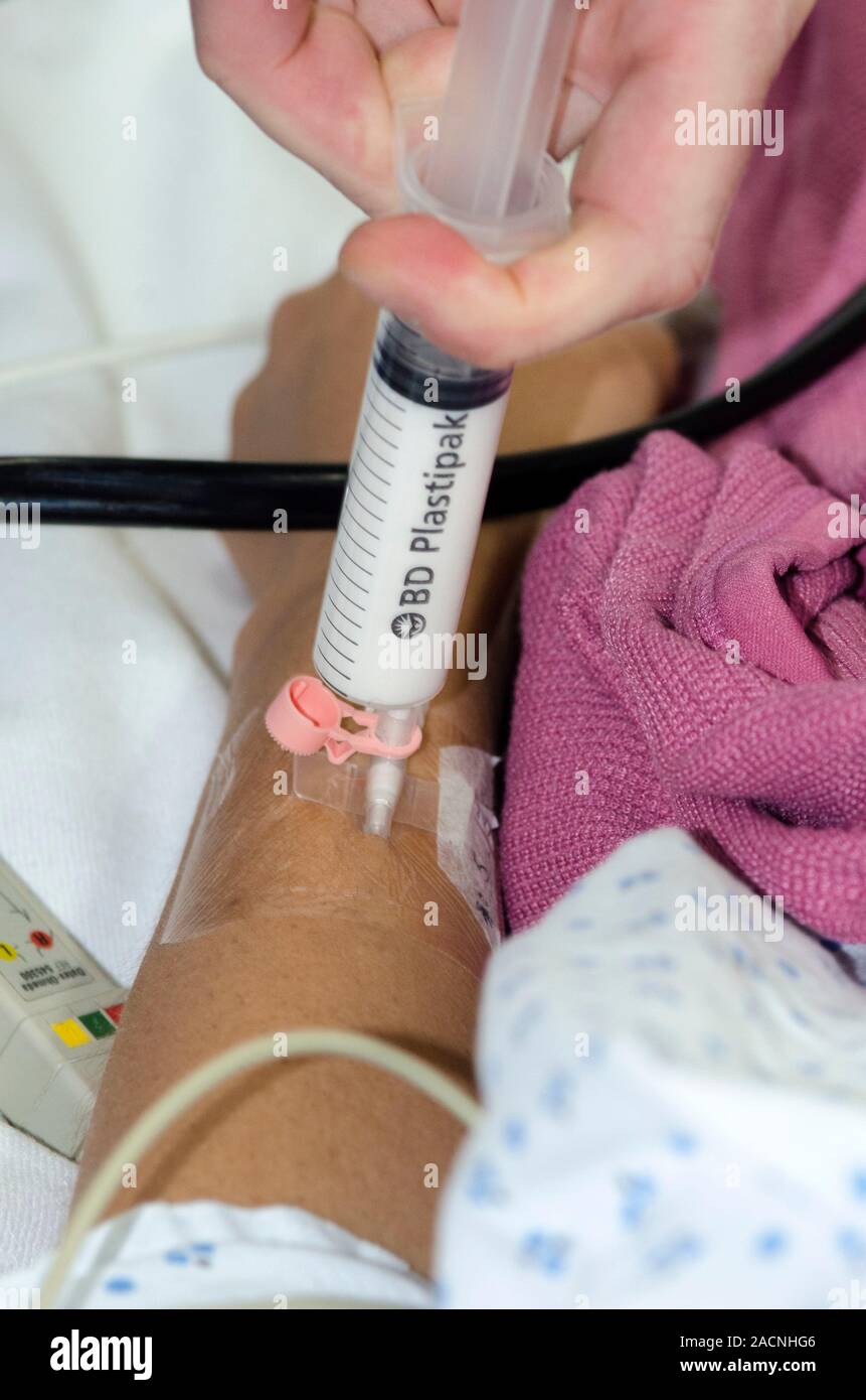 Administering general anaesthetic. Anaesthetist injecting a patient ...